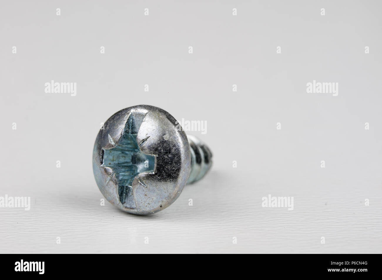 Screw head on a white table. Accessories for screw connections. Light ...