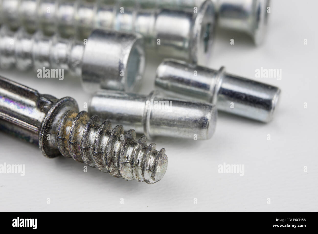 Screws on a white table. Accessories for screw connections. Light ...