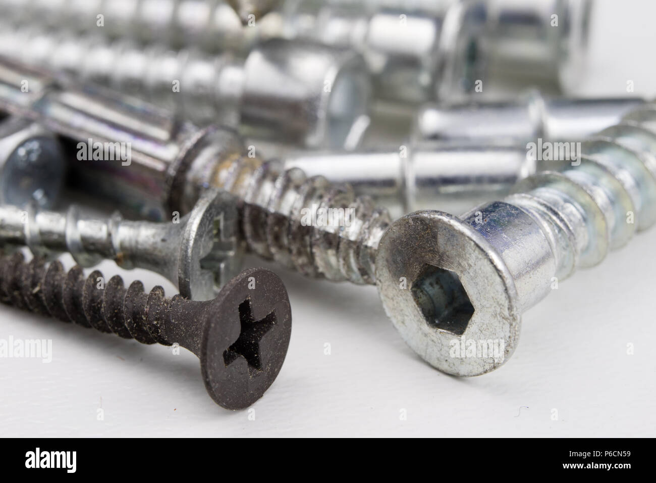 Screws on a white table. Accessories for screw connections. Light ...