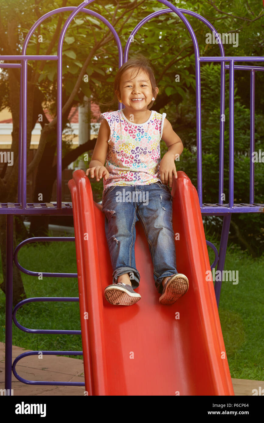 Little asian girl in playground. Happy asian girl sliding in park Stock ...