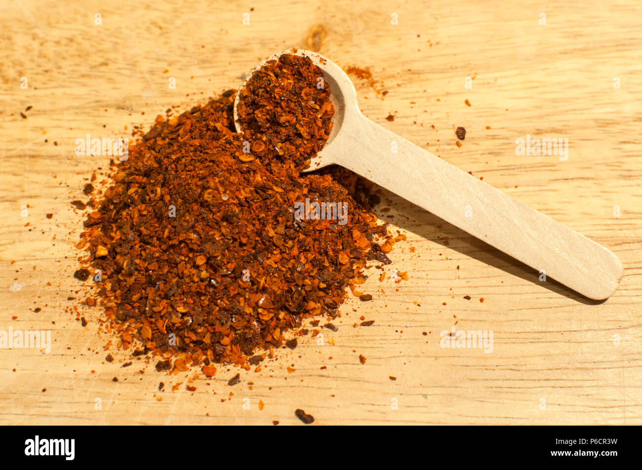 A pile of dried crushed coarse ground red hot pepper chilli flakes and ...