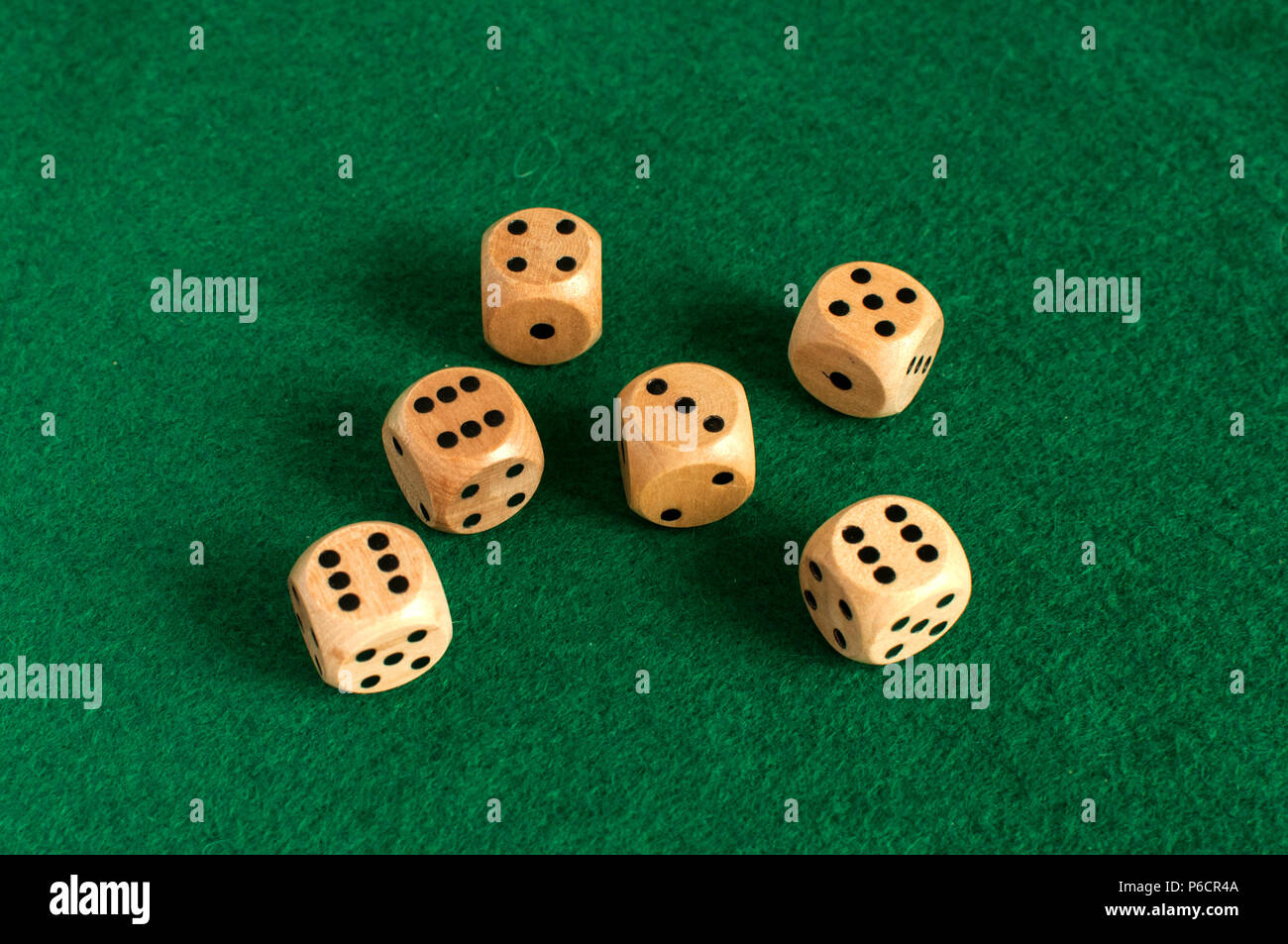 Wooden round corner dice six sided dots set for playing on dark green ...