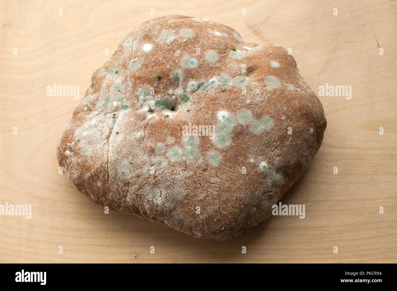 Moldy and musty round wheat bread on wooden background Stock Photo - Alamy