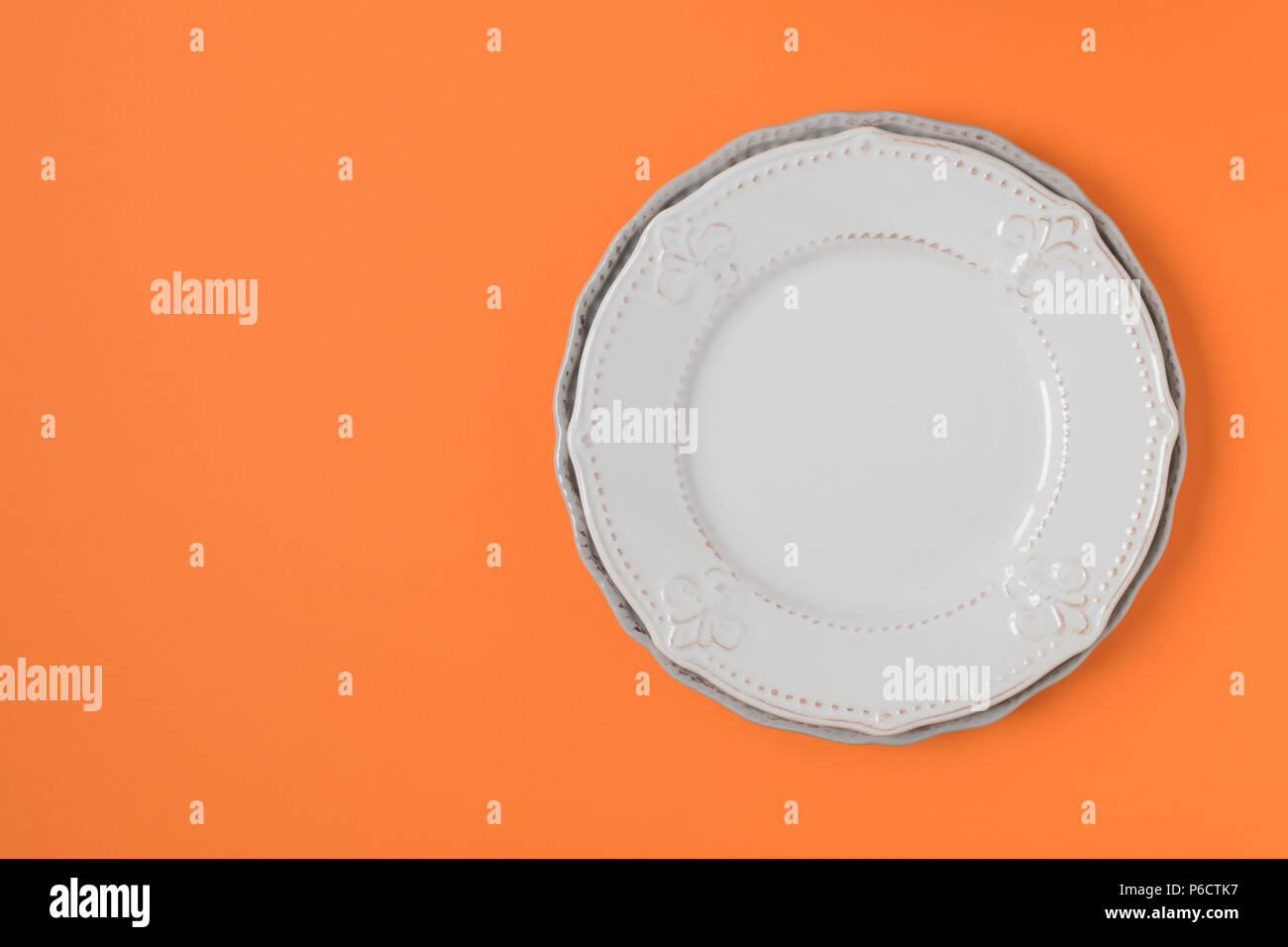 Two rustic plates on yellow background. Plates on the right side of ...