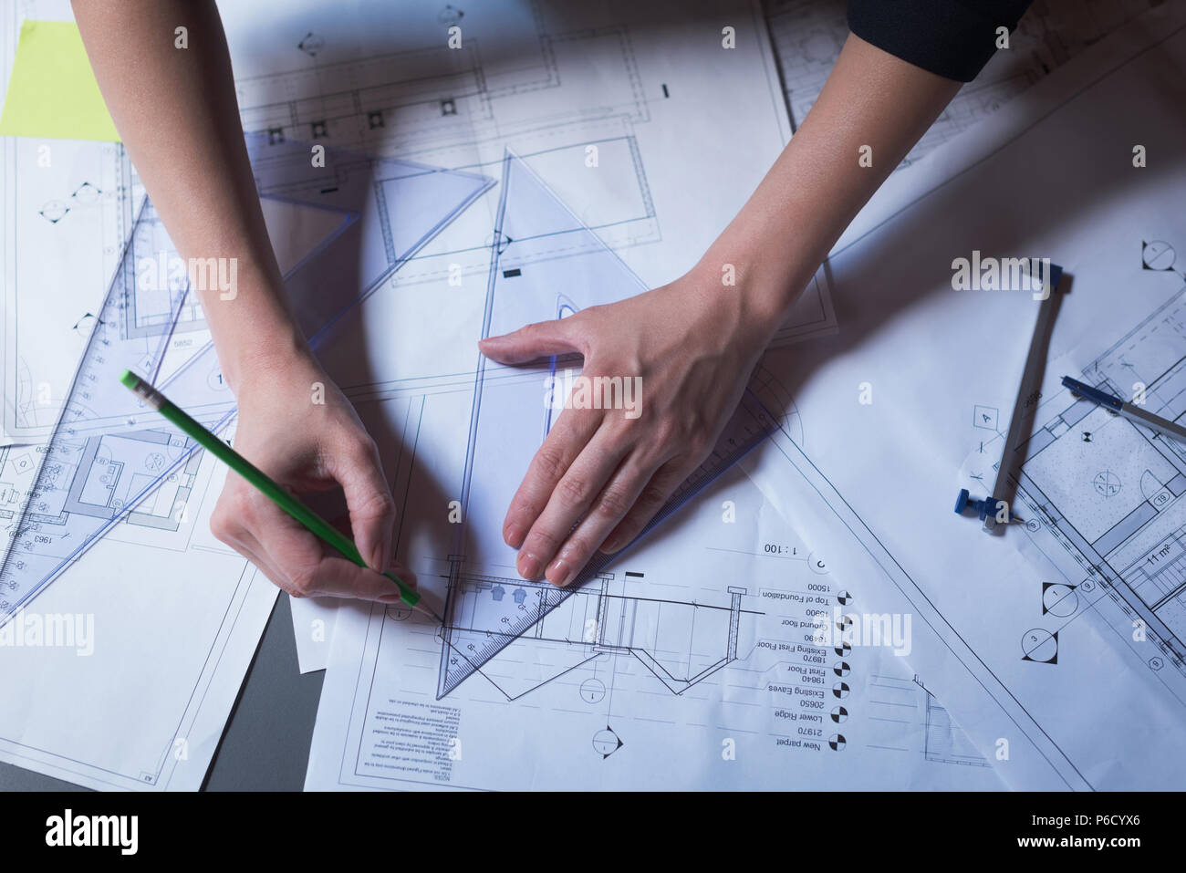Female executive working on blueprint in office Stock Photo - Alamy