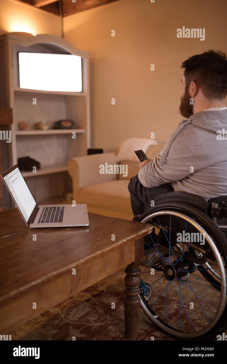 Disabled man watching television in living room Stock Photo - Alamy