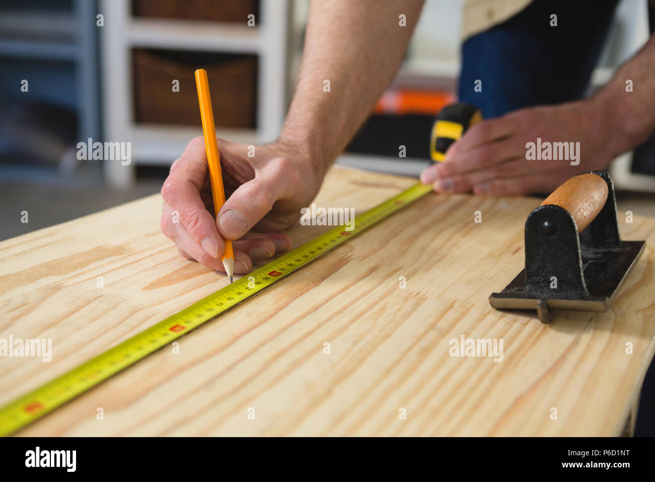 Male carpenter measuring and marking wood in workshop Stock Photo - Alamy