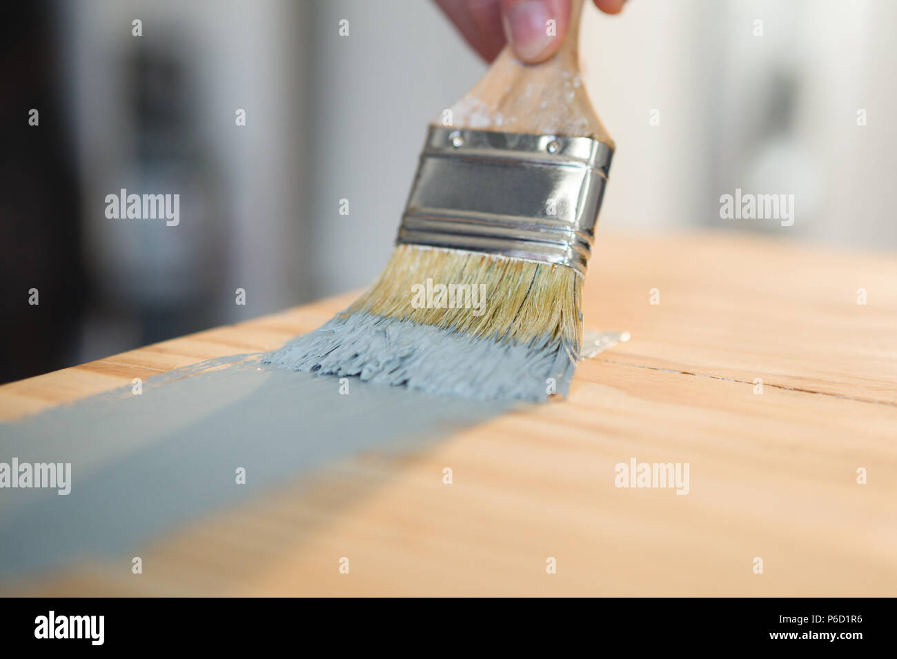 Male carpenter painting a table Stock Photo - Alamy