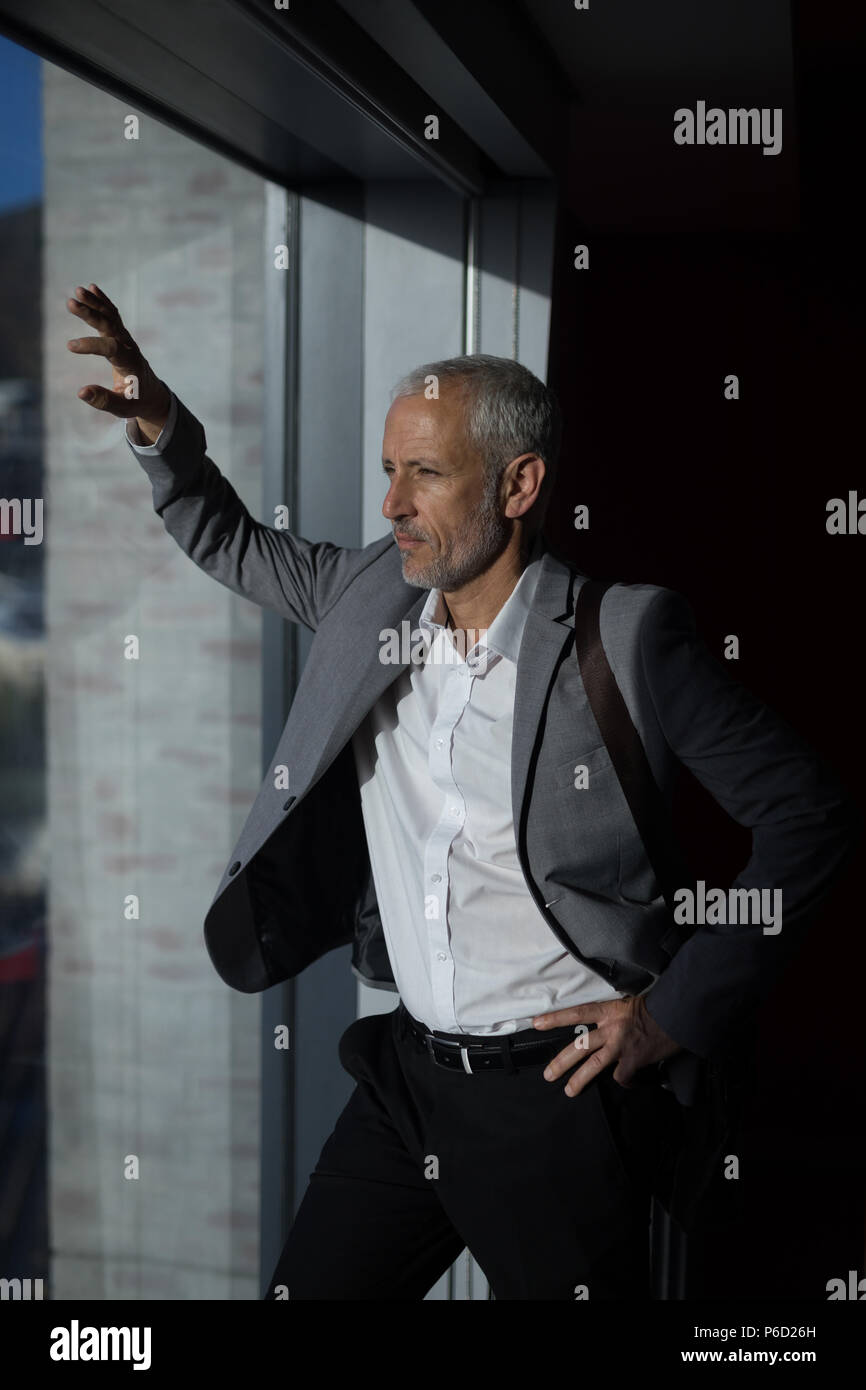 Businessman looking outside the window Stock Photo - Alamy