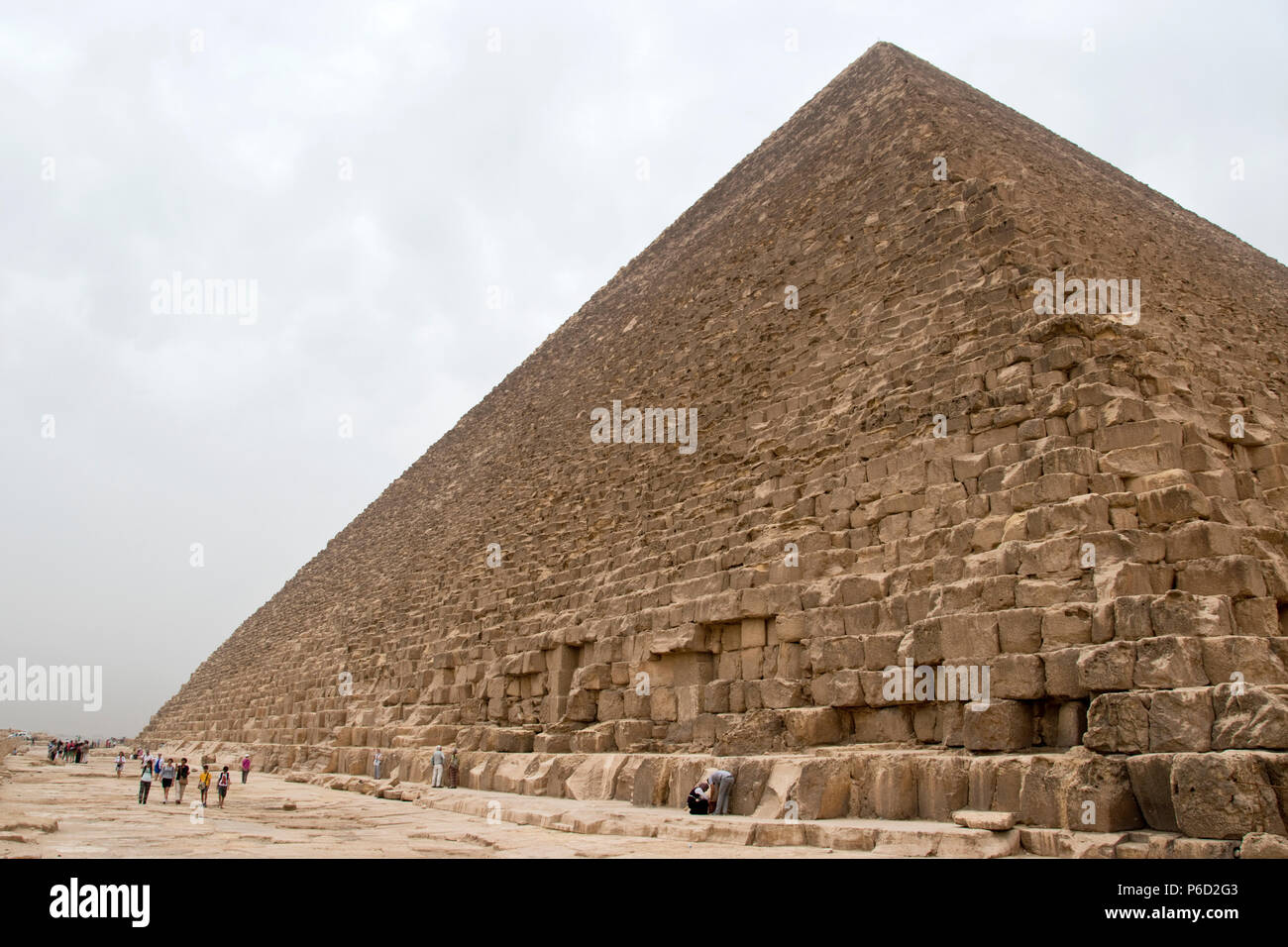 Tourists walk around the base of the Great Pyramid of Giza (Pyramid of ...