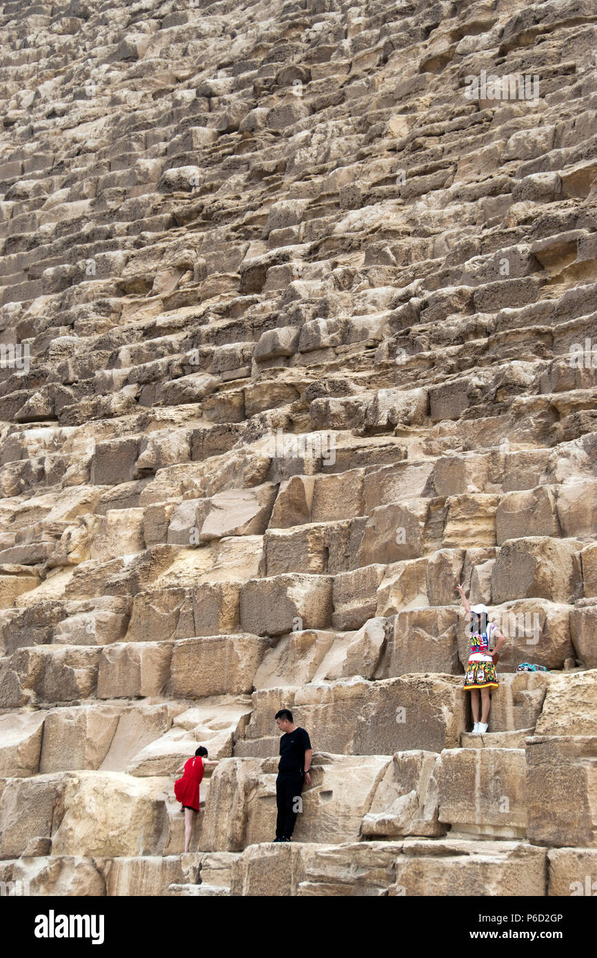 Asian tourists pose for photos in front of the Great Pyramid of Giza ...