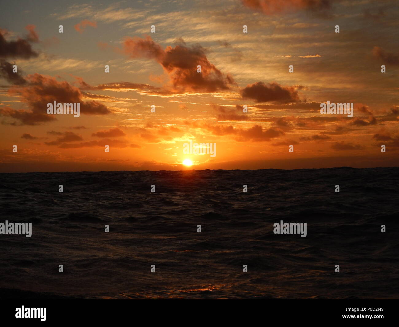 Sunset in the ocean Stock Photo - Alamy