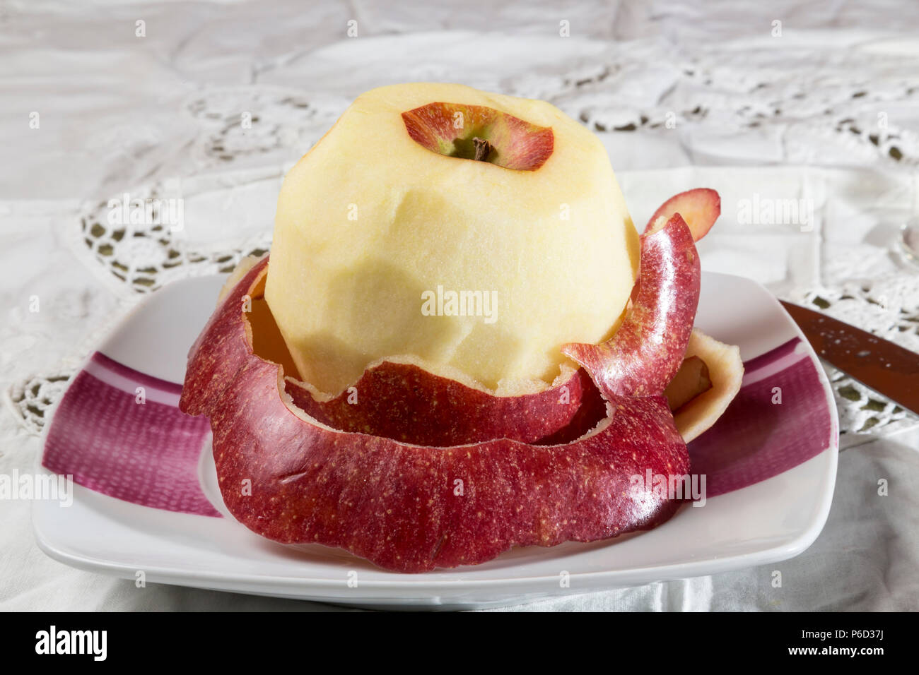 peeled apple with the skin around and put on a plate Stock Photo - Alamy
