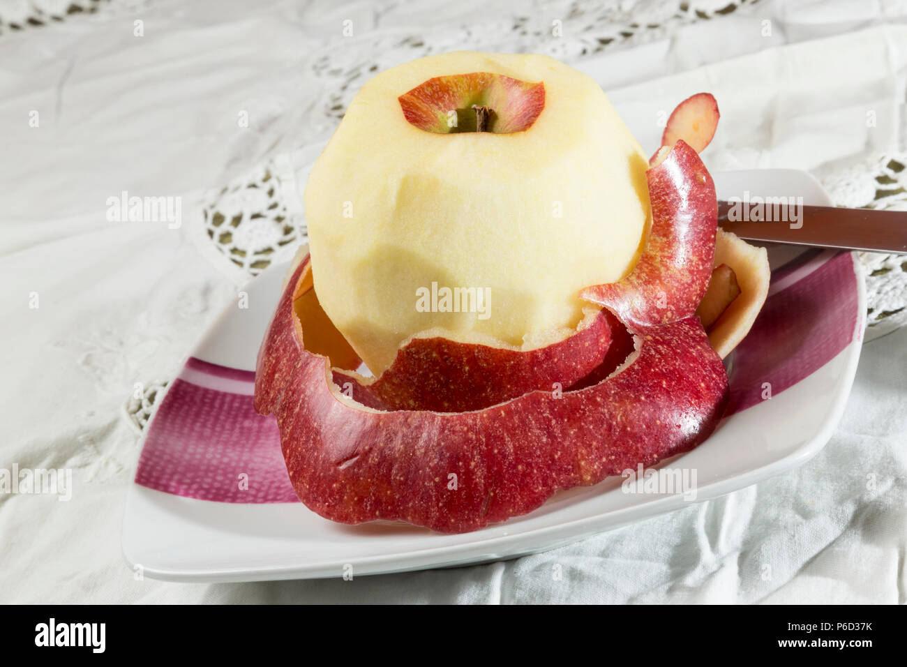 peeled apple with the skin around and put on a plate Stock Photo - Alamy