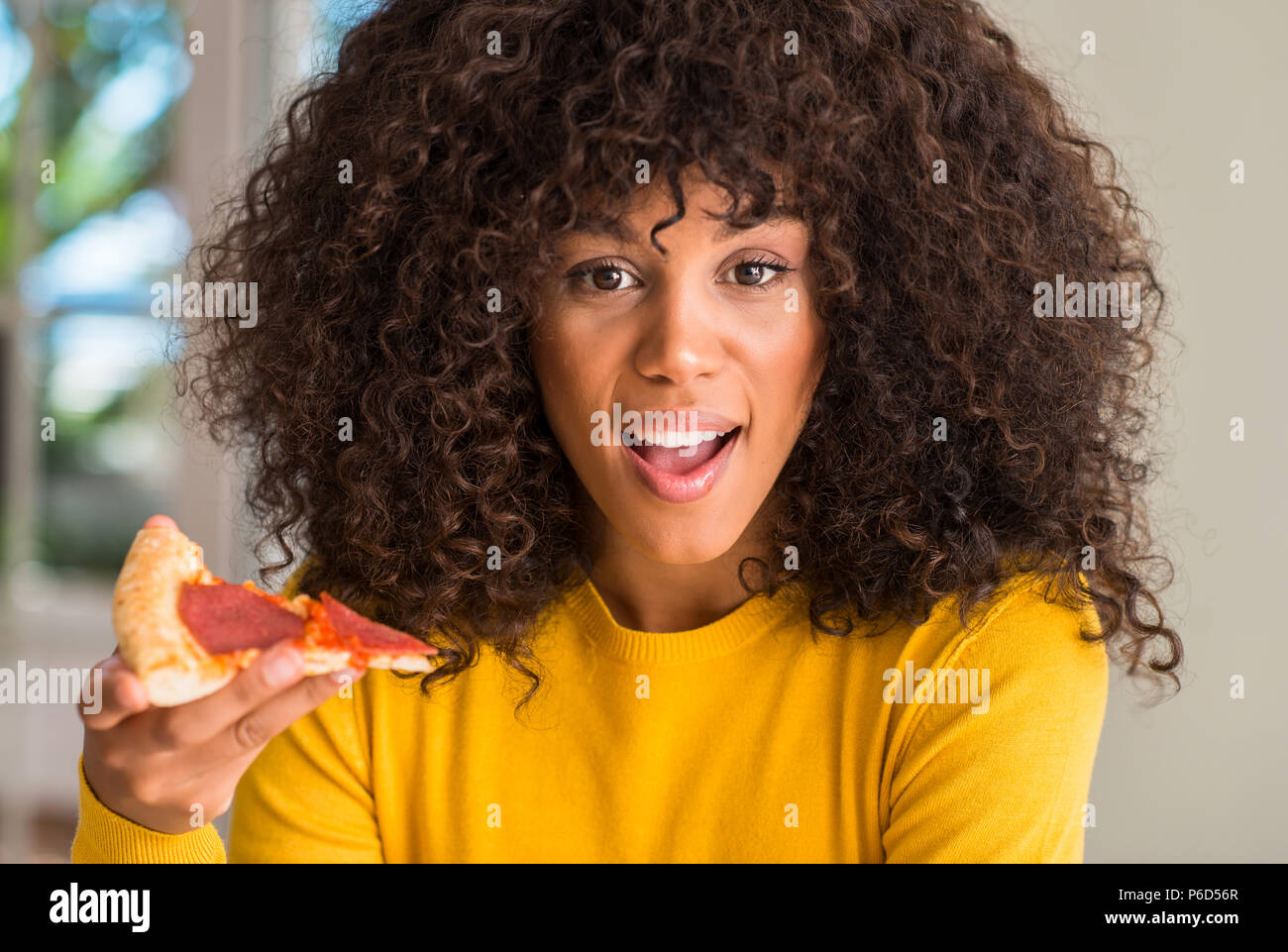 African american woman ready to eat pepperoni pizza slice scared in ...