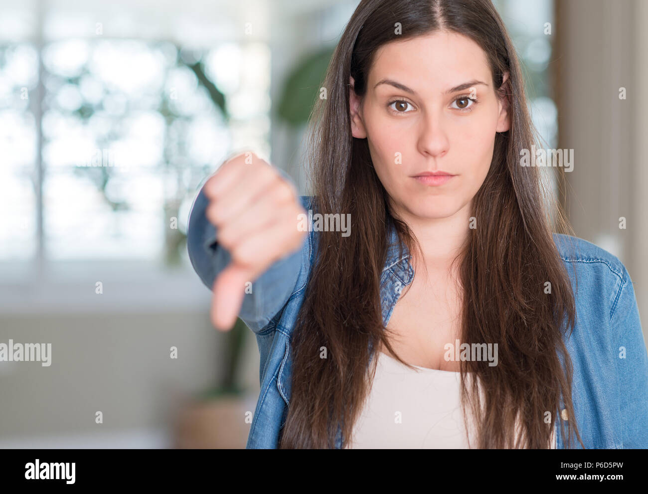Young beautiful woman at home with angry face, negative sign showing ...