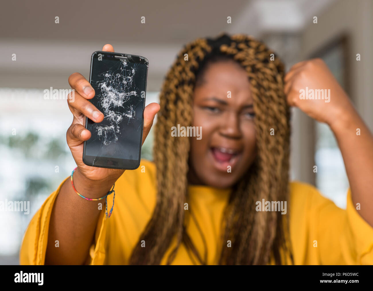 African american woman showing broken smartphone annoyed and frustrated ...