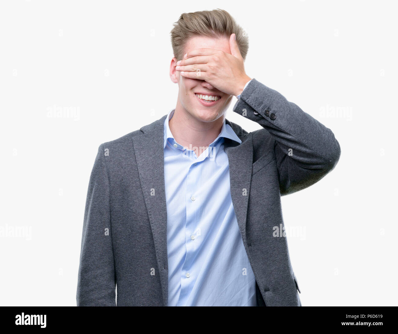 Young handsome blond business man smiling and laughing with hand on ...