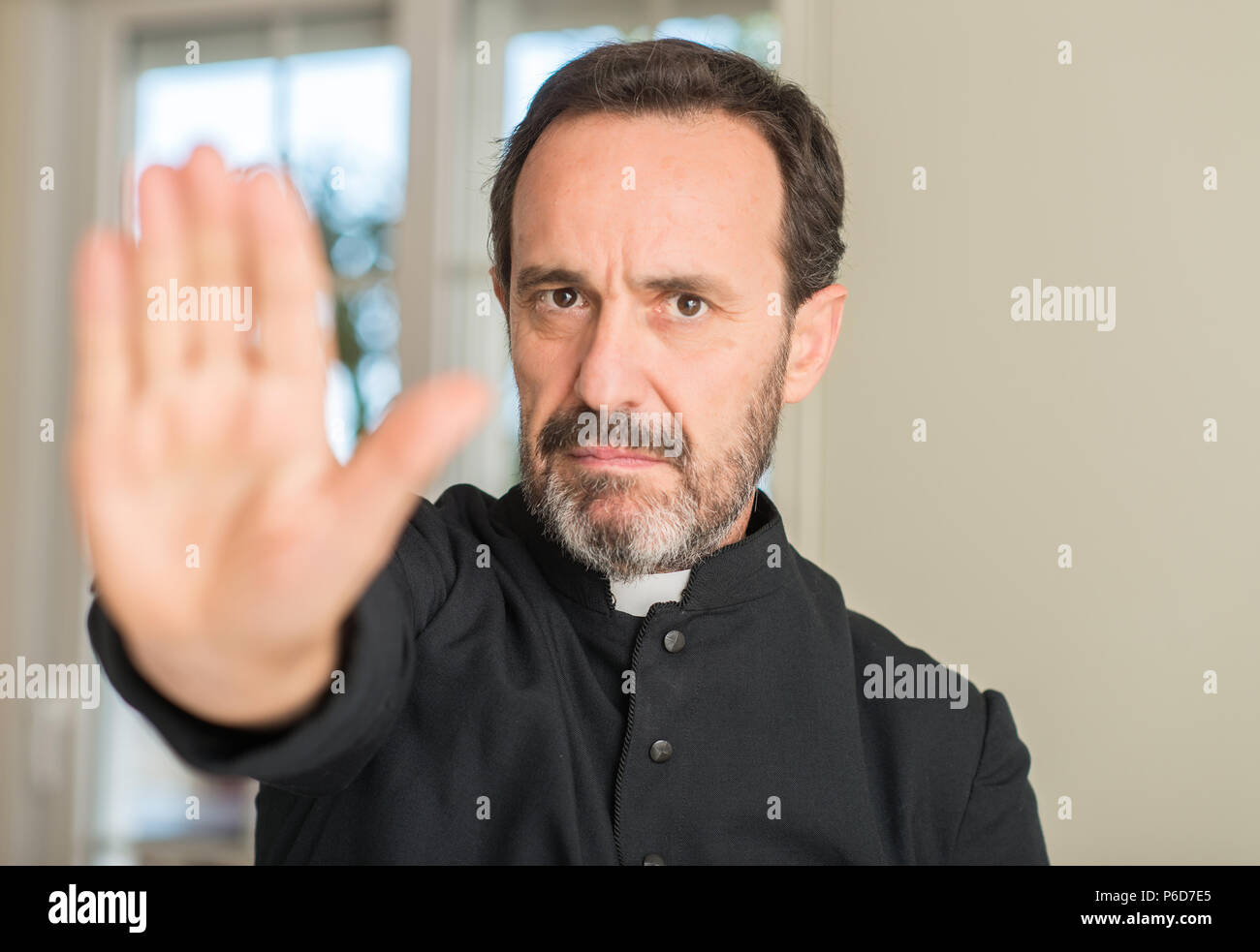 Christian priest man with open hand doing stop sign with serious and ...