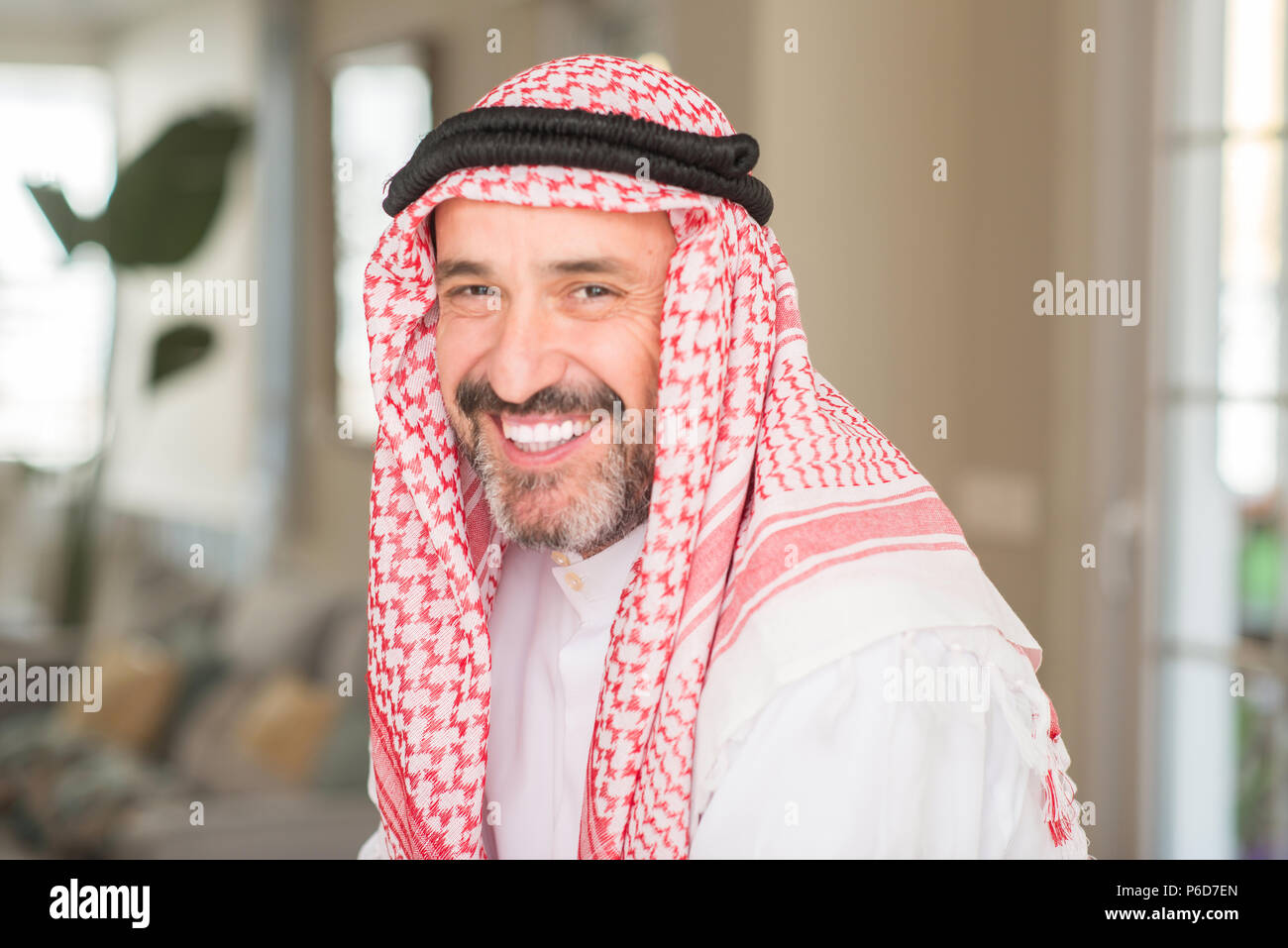 Middle age arabian man at home with a happy face standing and smiling ...