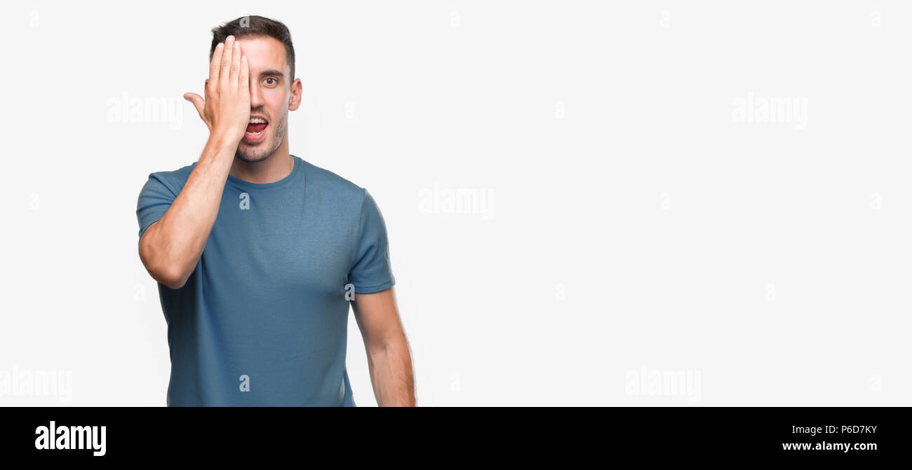 Handsome young casual man covering one eye with hand with confident ...