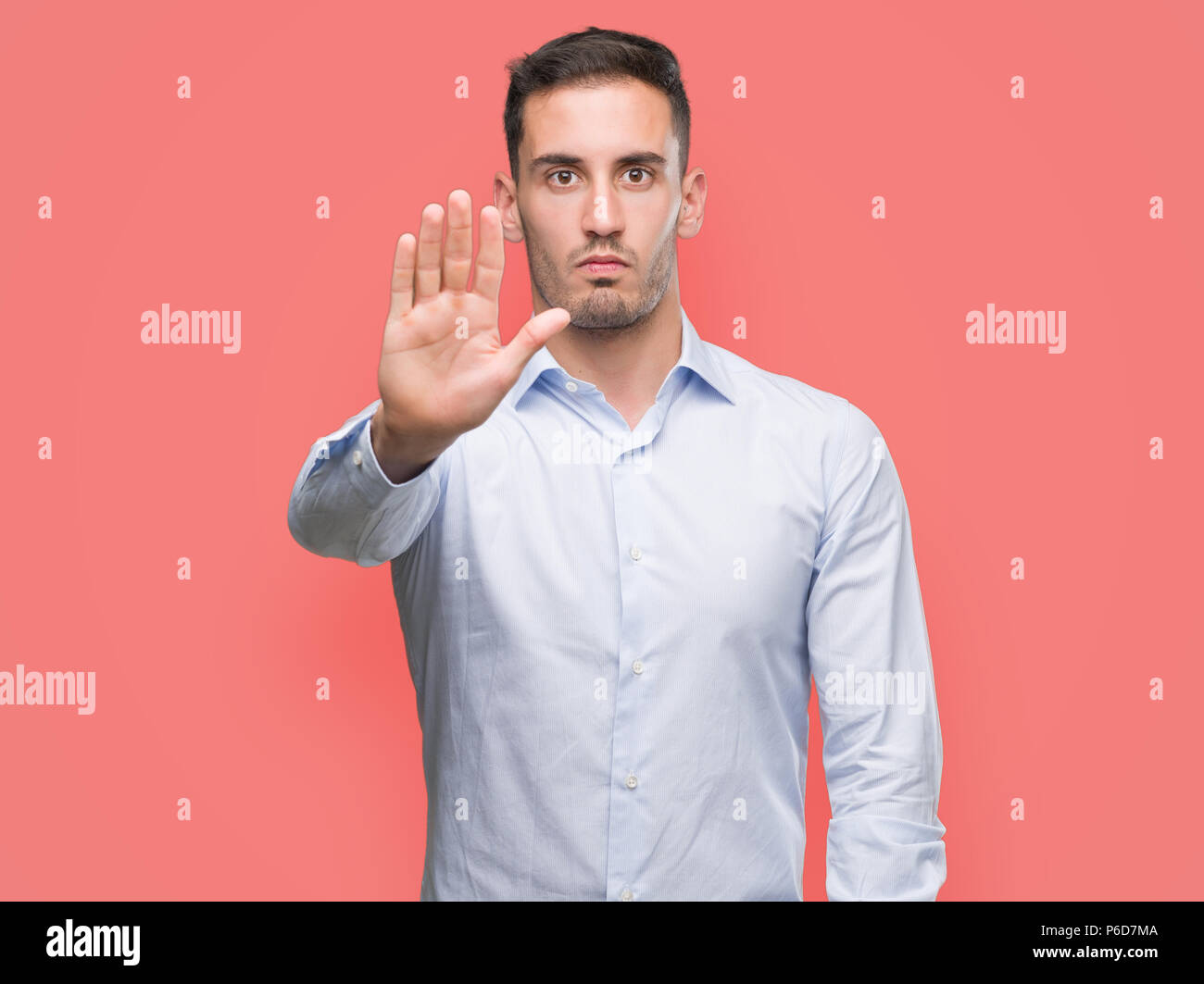 Handsome young businessman doing stop sing with palm of the hand ...