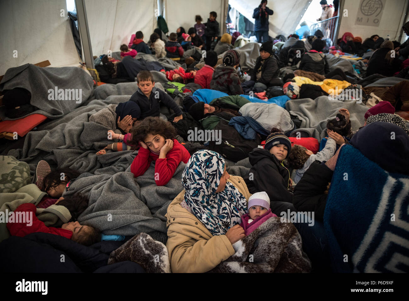 People sleep on the ground inside a shelter close to th6e border gate ...