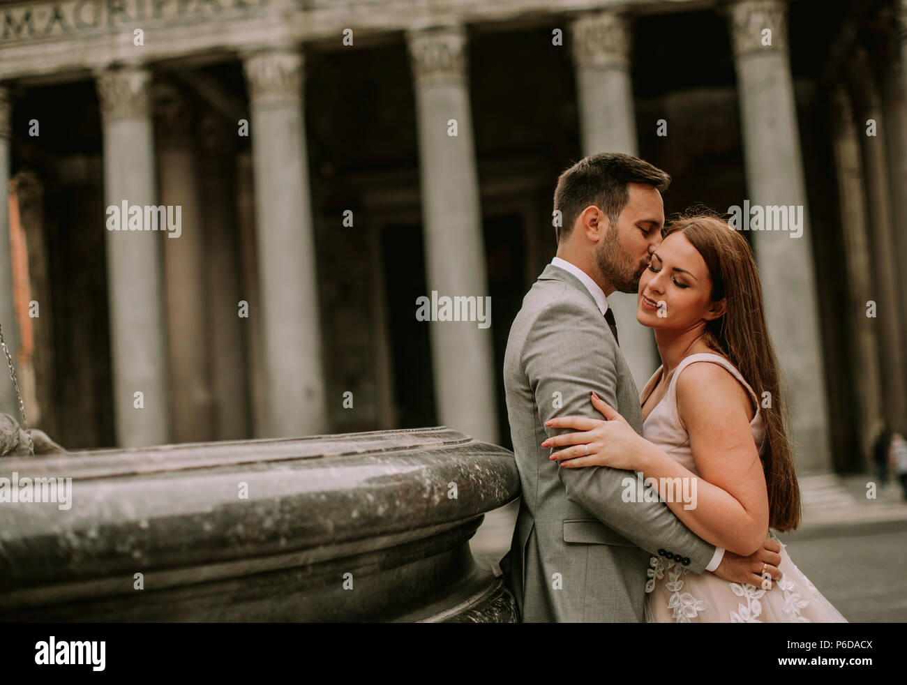 Young attractive newly married couple posing in Rome with beautiful and ...