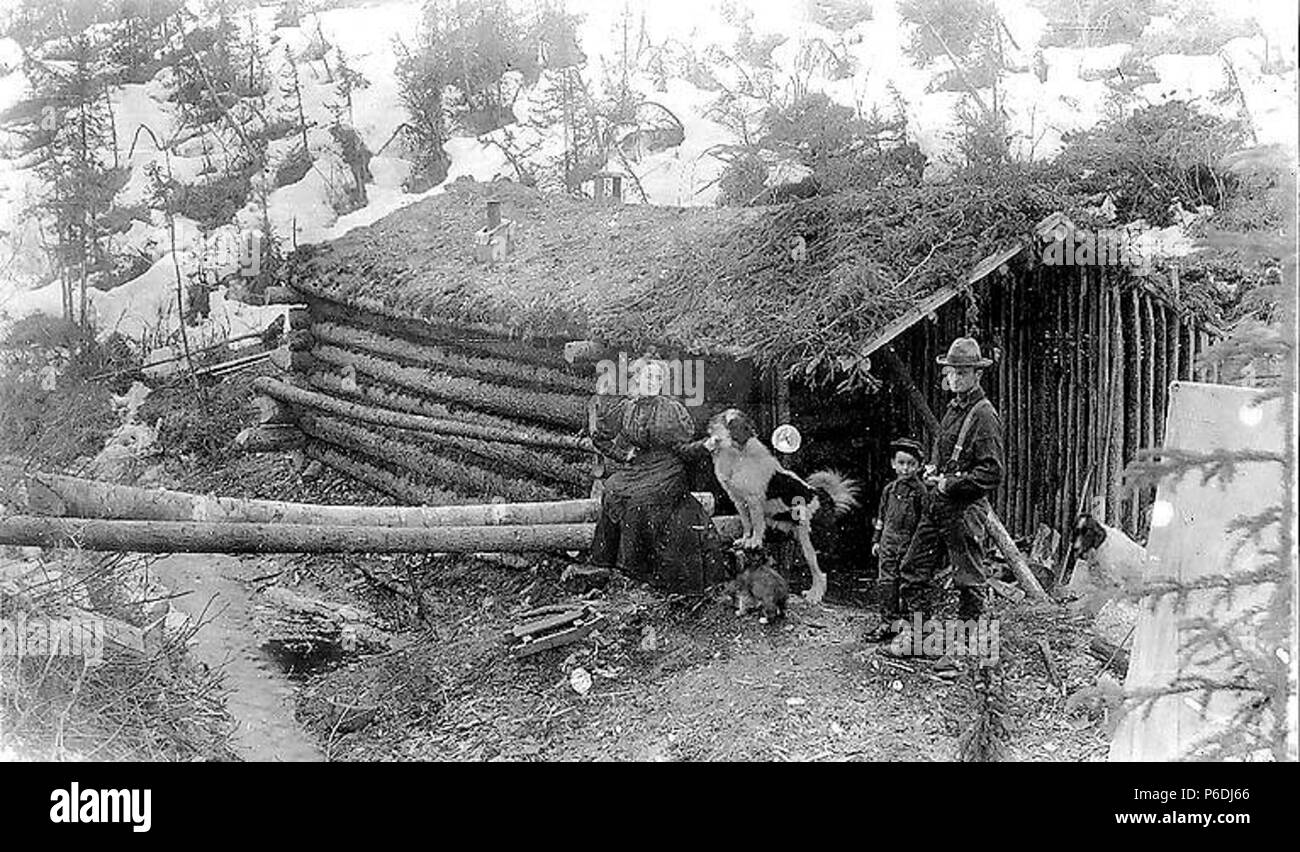 . English: J.W. Slayden and family in front of log cabin, Stampede ...