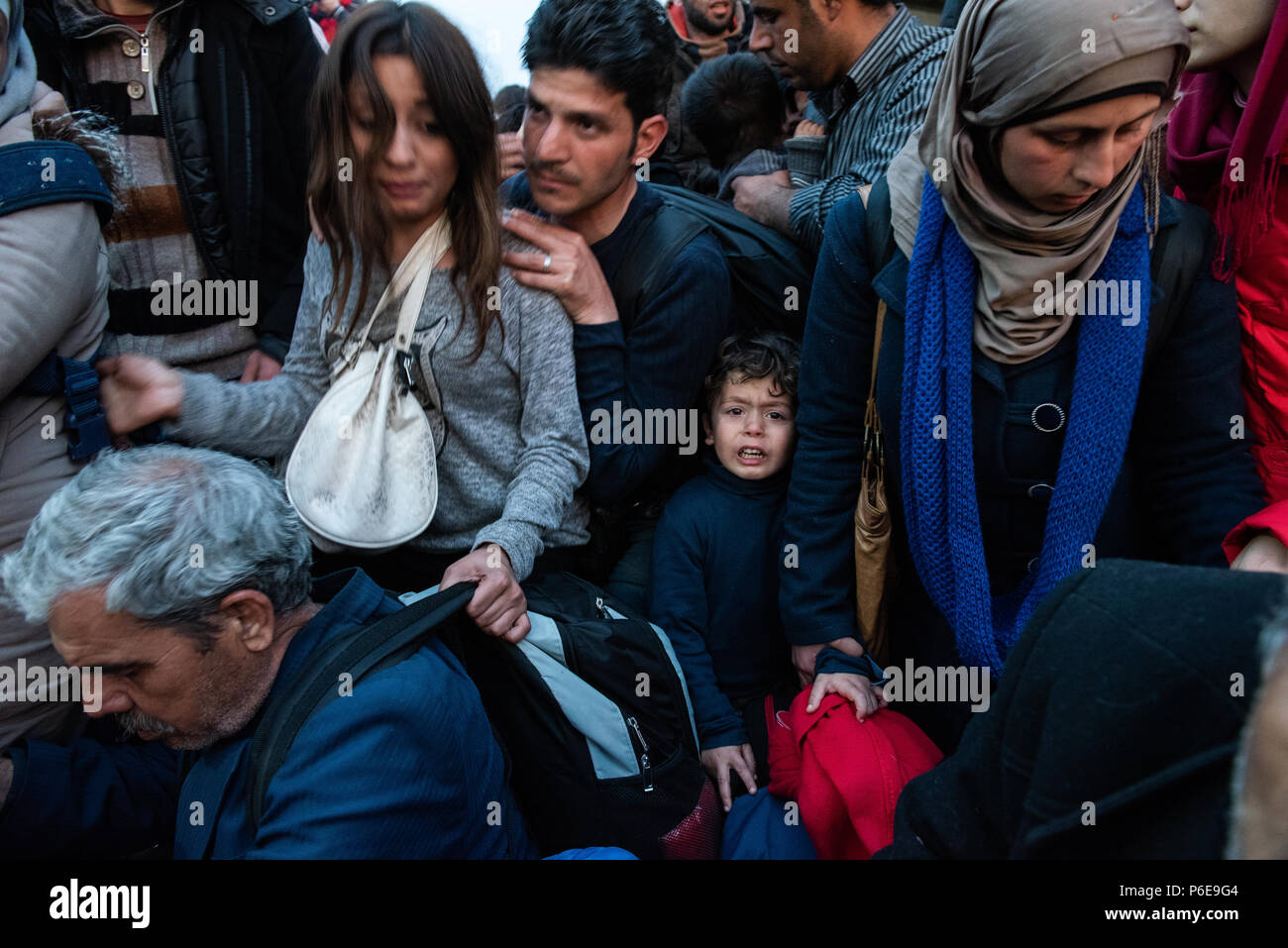 A refugee boy cries as he and others wait to cross the border at the ...