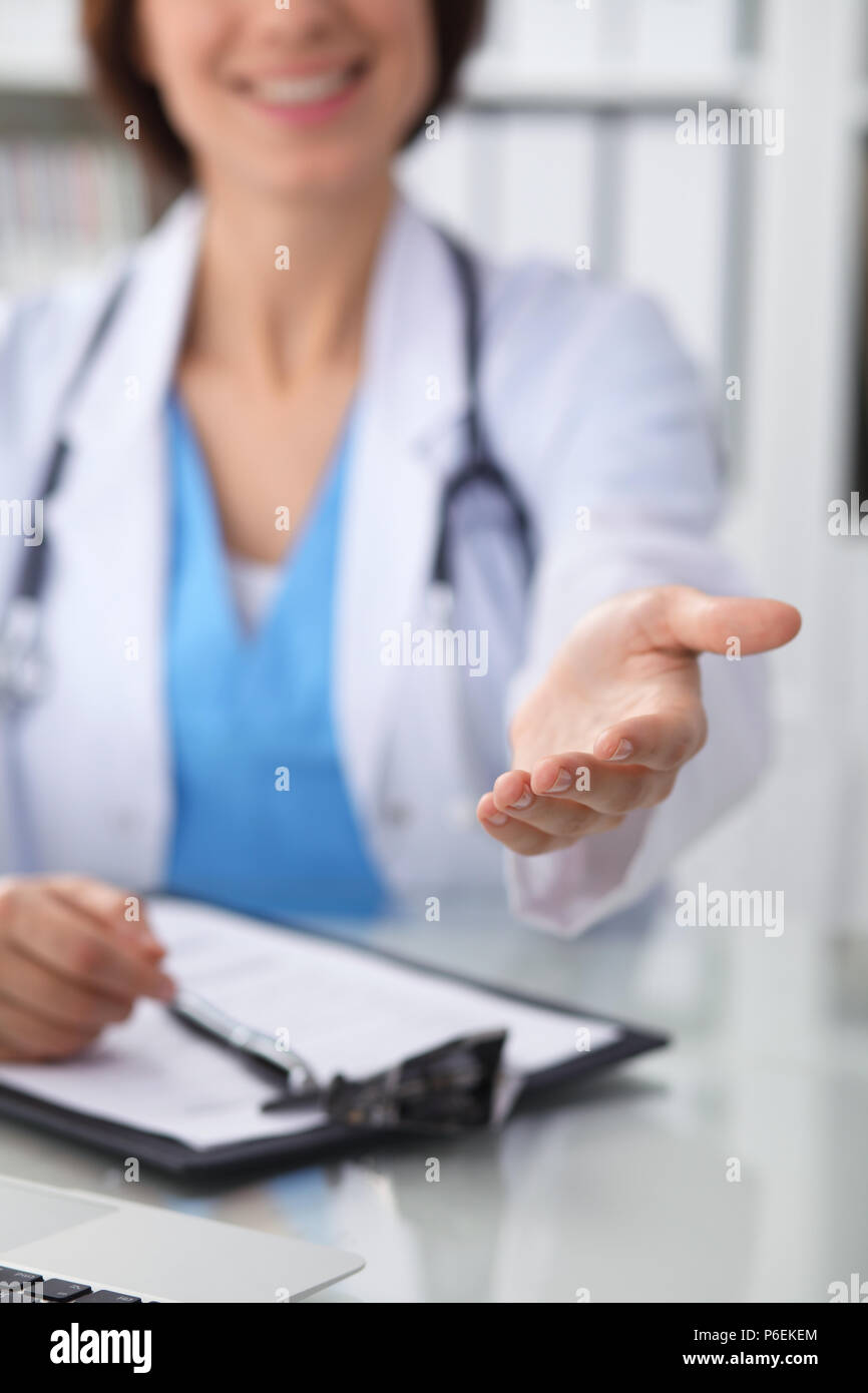 Closeup of medicine doctor offering helping hand or handshake ...