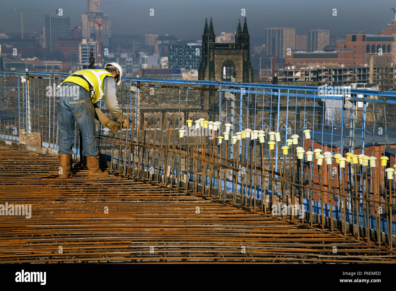 Man places safety caps on Rebar on working construction building site ...