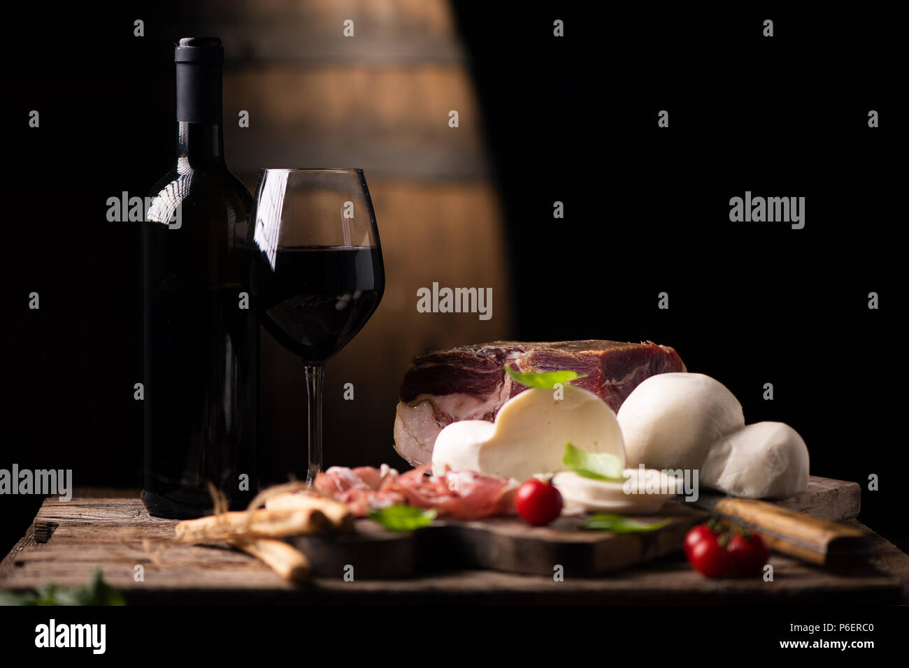 Bottle of wine with a glass on a table with rustic traditional italian ...