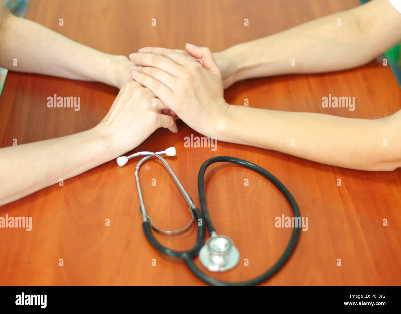 Female doctor's hands holding patient's hand for encouragement and ...
