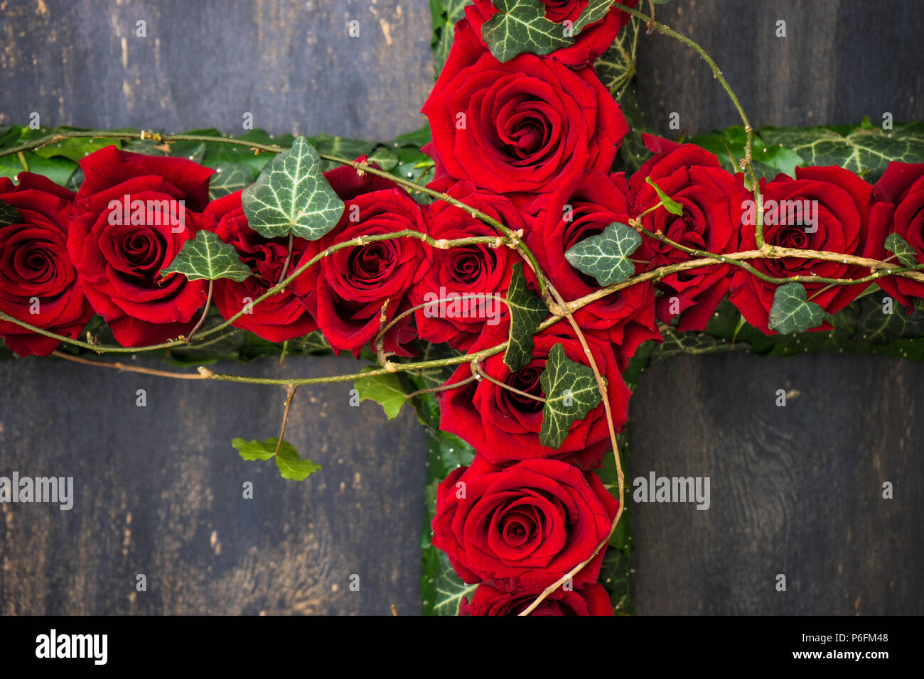 Red roses in floral funerary concept on dark wooden background with ...