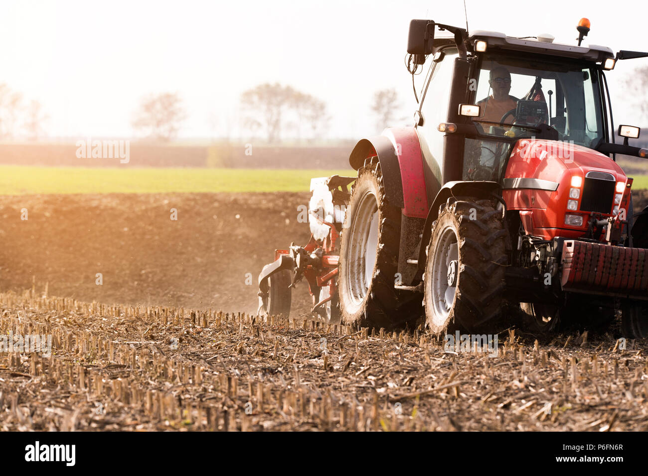 Tractor plowing fields -preparing land for sowing Stock Photo - Alamy