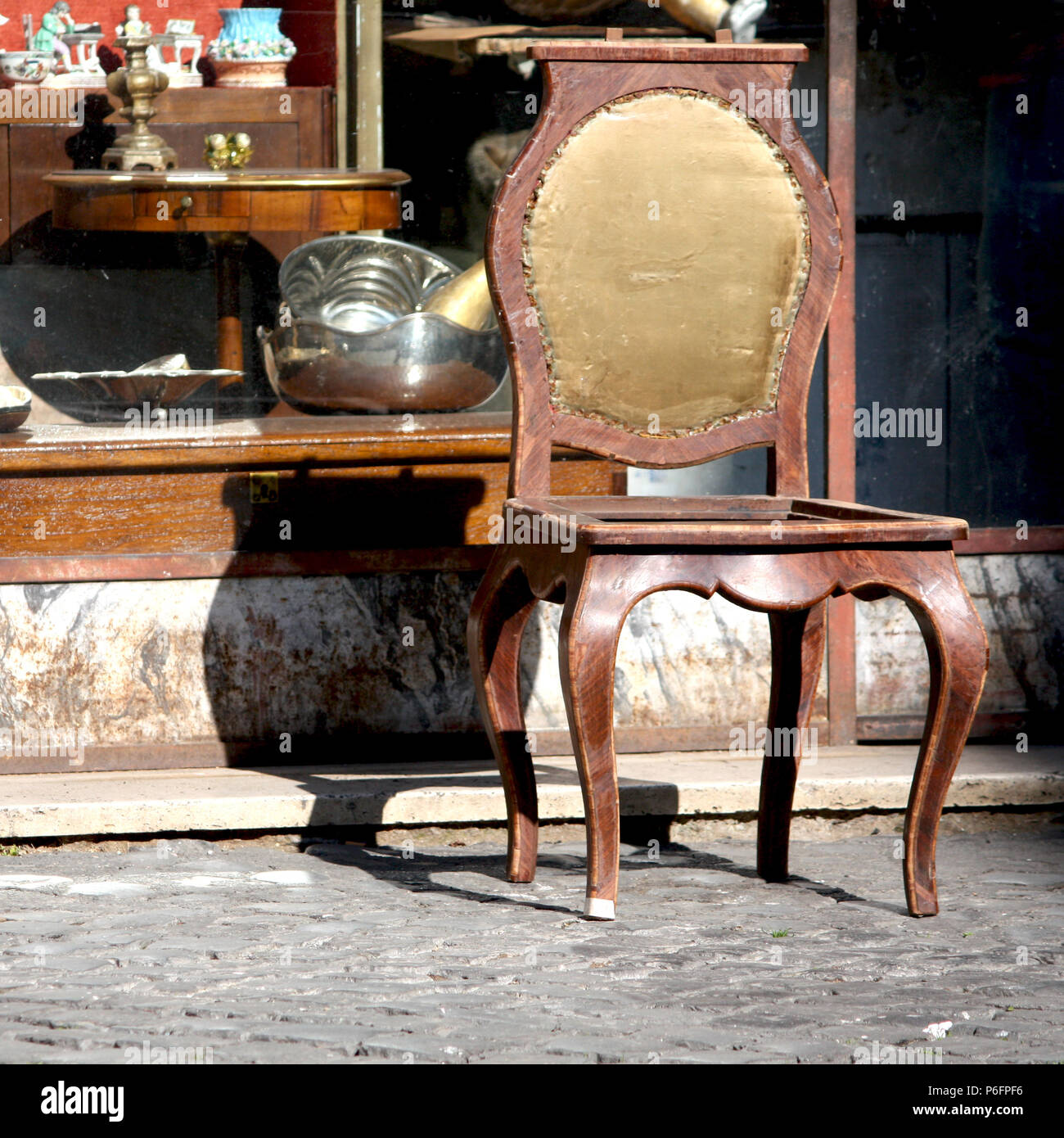 Old ruined chair in front of an antiques store Stock Photo - Alamy