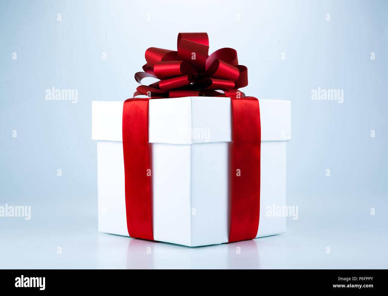 White gift box with red ribbon and bow on grey background Stock Photo ...