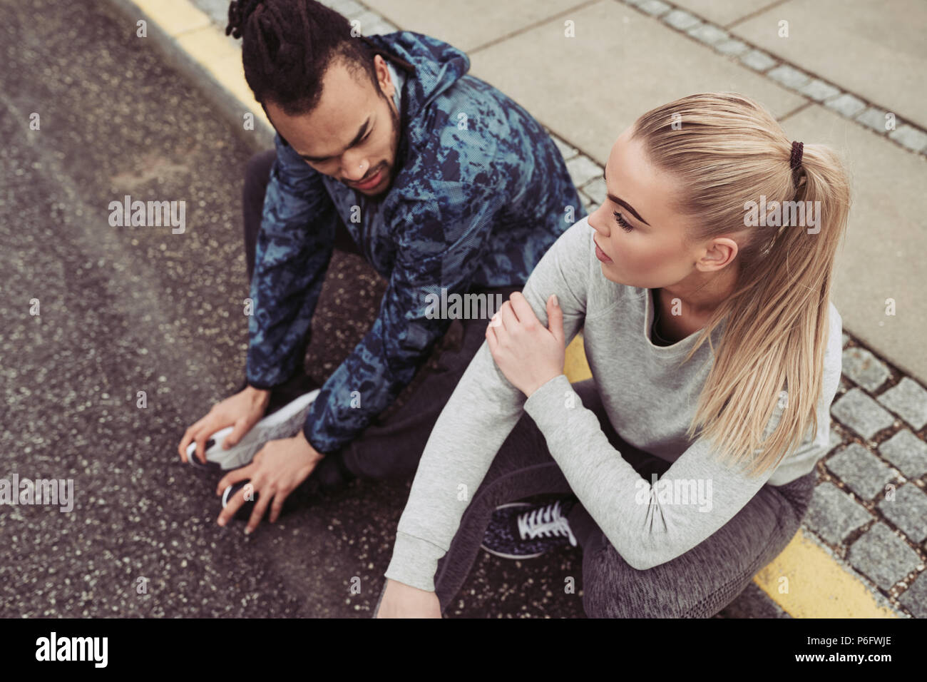 Young woman sitting on curb hi-res stock photography and images - Alamy