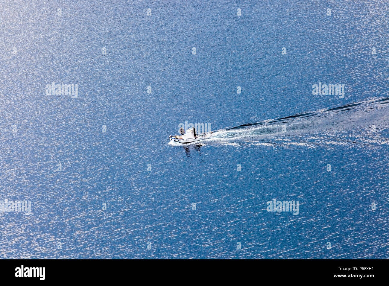 Lonely boat in the calm blue sea Stock Photo - Alamy