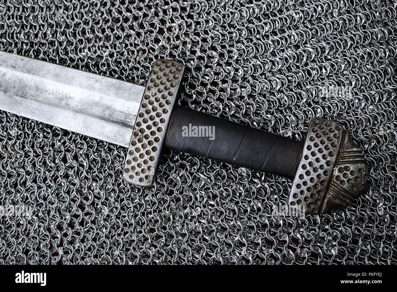 Handle and part of the blade of the medieval sword lying on the metal ...