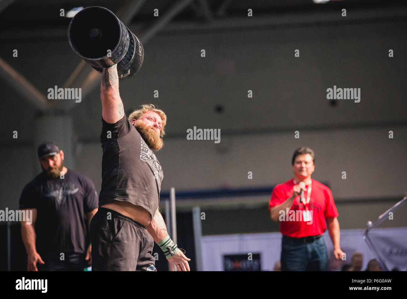 man competing in a dumbbell competition on stage Stock Photo - Alamy