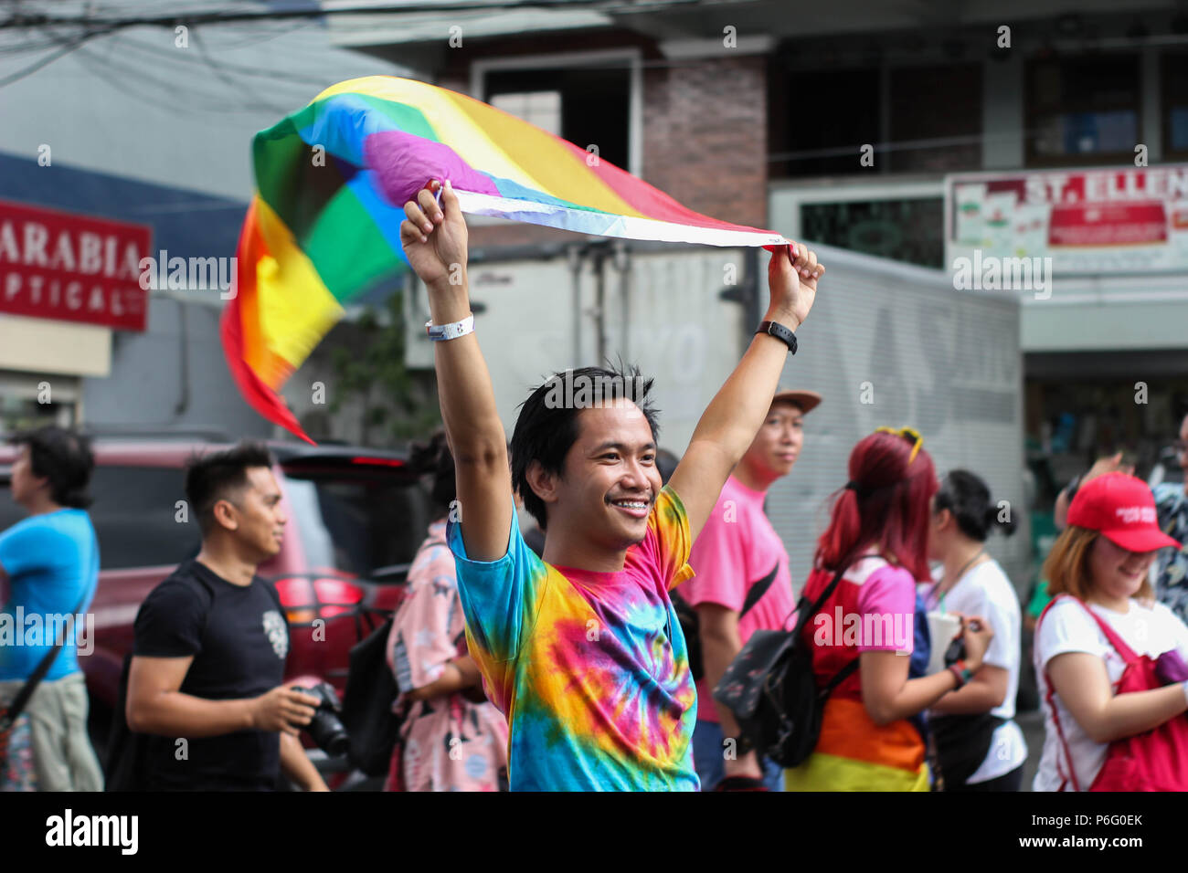 A Pride Parade member holding the rainbow flag. Thousands gathered ...
