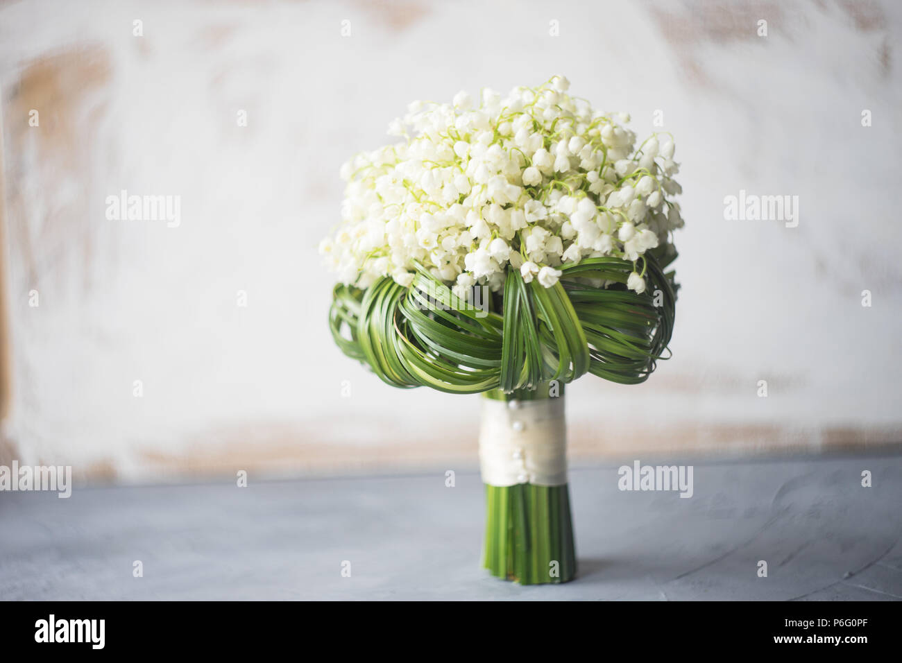 Beautiful may lilies in bride bunch on rustic background with copy ...