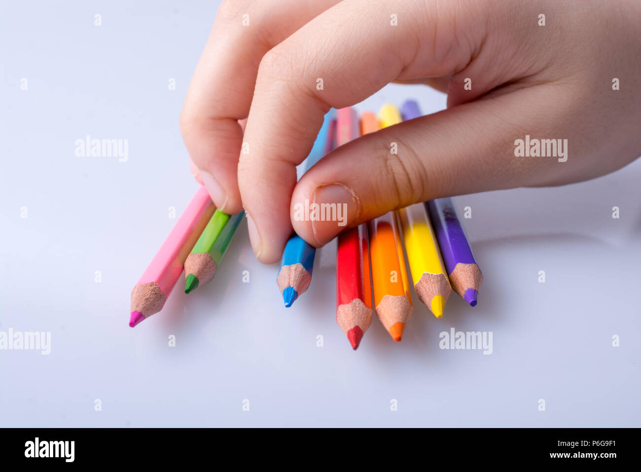 Hand holding color Pencils placed on a white background Stock Photo - Alamy