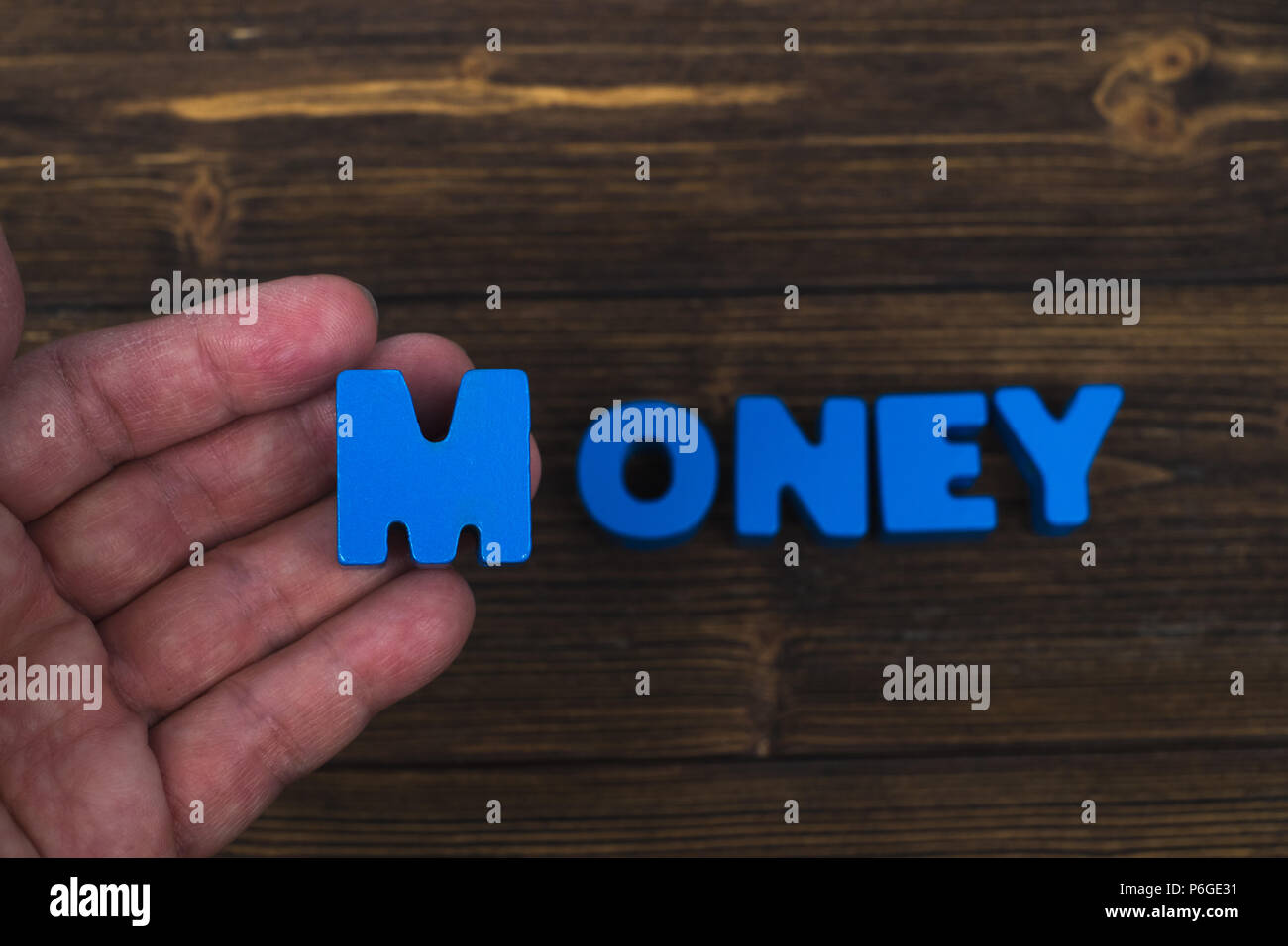Hand and finger arrange text letters of MONEY word on wood table, with ...