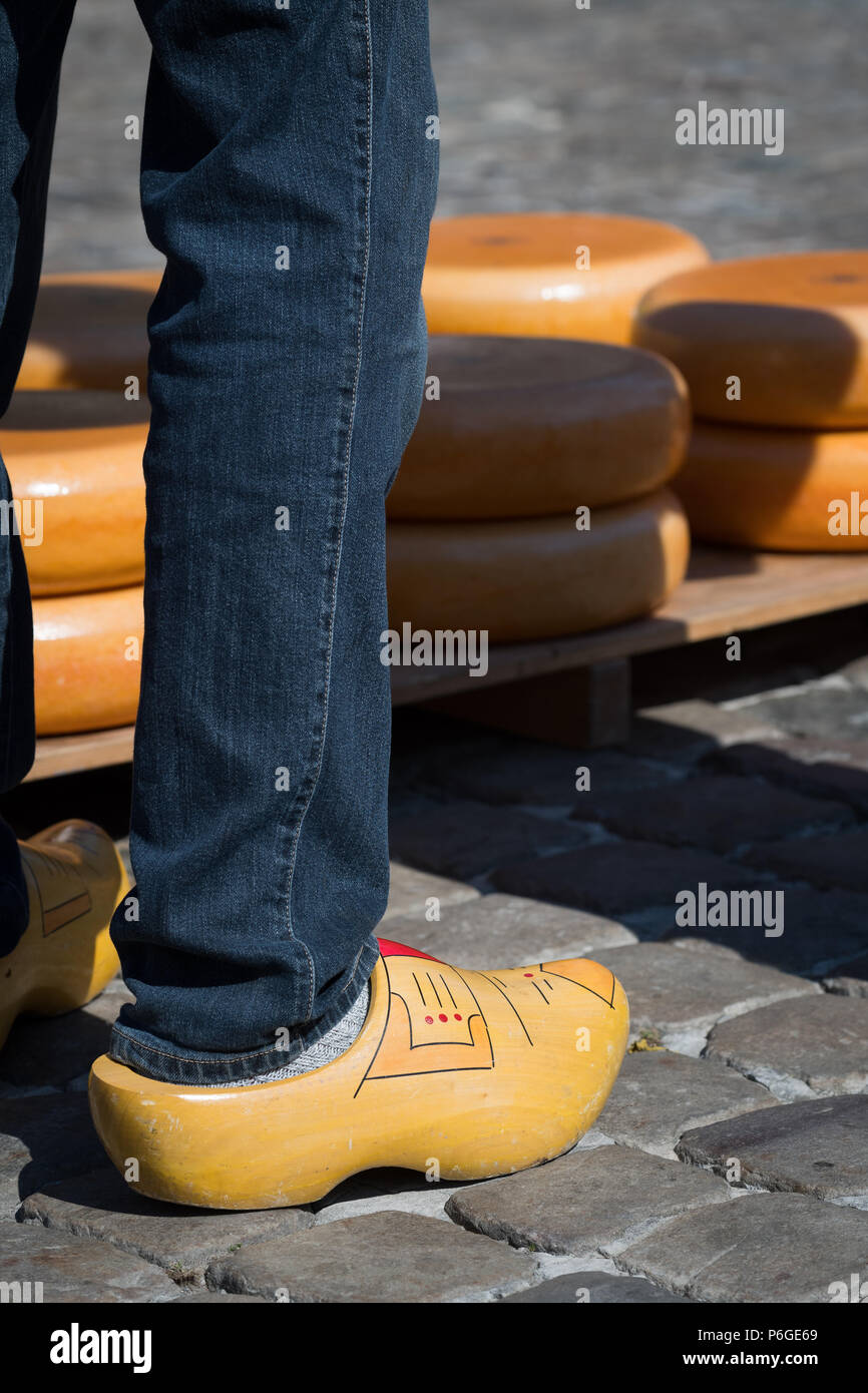 Traditional Dutch clogs and stacked cheeses at the Gouda cheese market ...