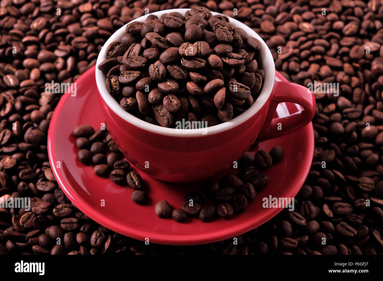 Red coffee cup filled with roasted beans closeup Stock Photo - Alamy