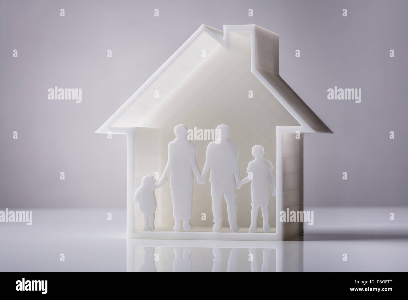 Family Figures Standing Inside House Model On Reflective Background ...