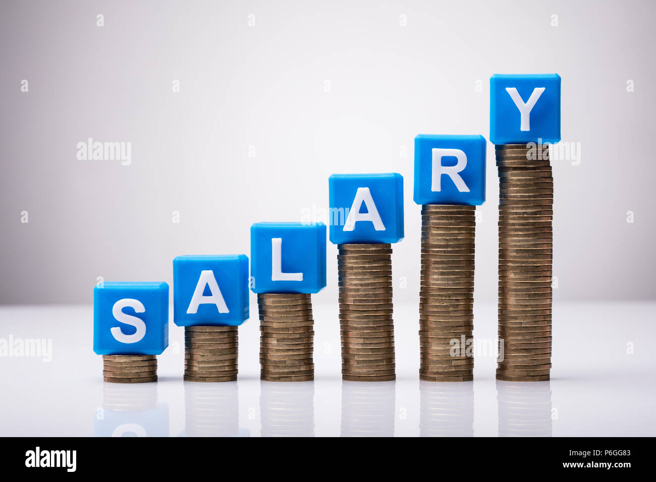 Blue Salary Cubic Blocks On Increasing Stacked Coins Against White ...
